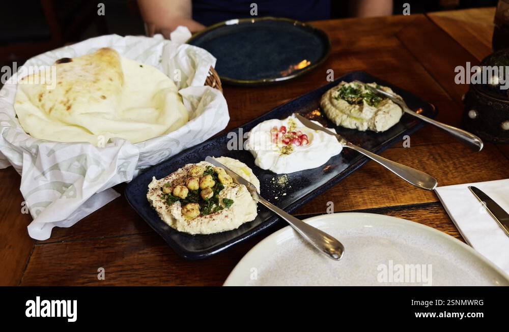 Delicious Arabic creams baba ghanoush, labneh, hummus and Arabic bread ...