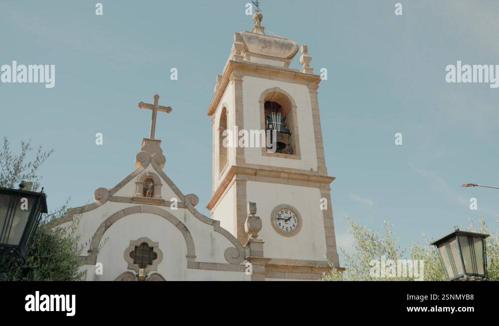 Classic church facade with a bell tower and cross, captured under a ...