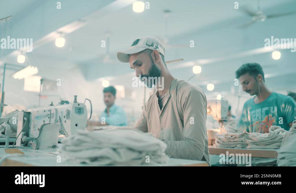 Young Pakistani man sewing clothes in industry of Karachi, Pakistan ...