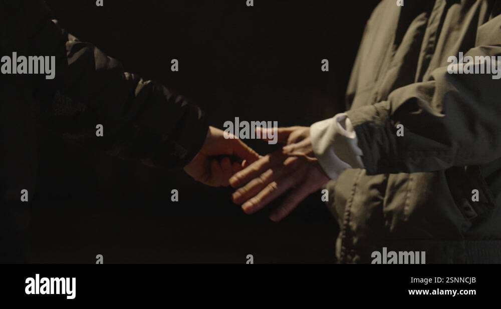 two young men hand over an object Stock Video Footage - Alamy