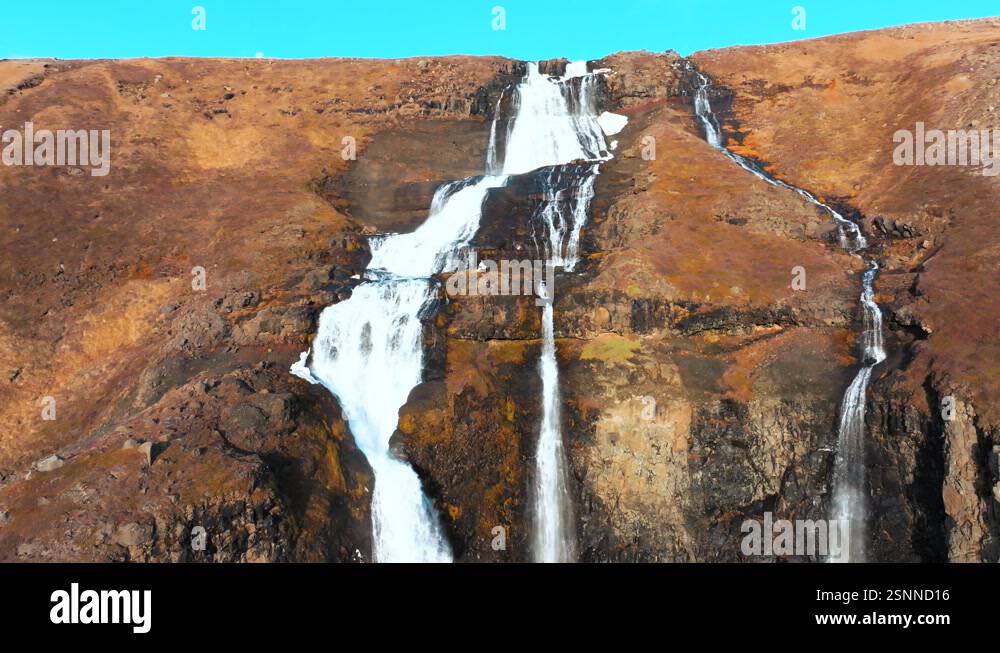 Triple waterfall flowing down a mountainside in Iceland - pullback ...