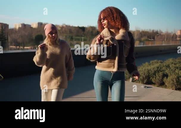 Two friends joyfully performing a viral dance in a sunny outdoor ...