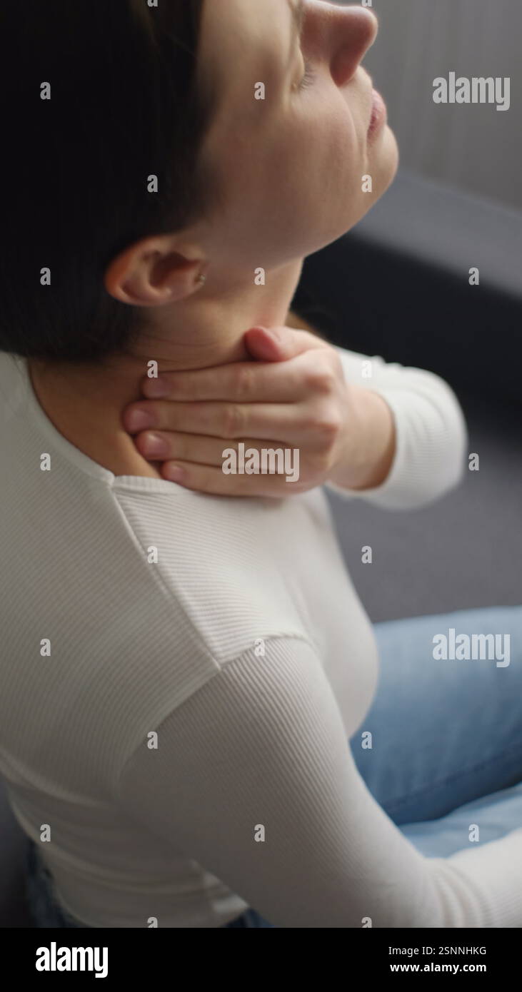 Vertical footage of tired young woman painful with neck pain body ache ...
