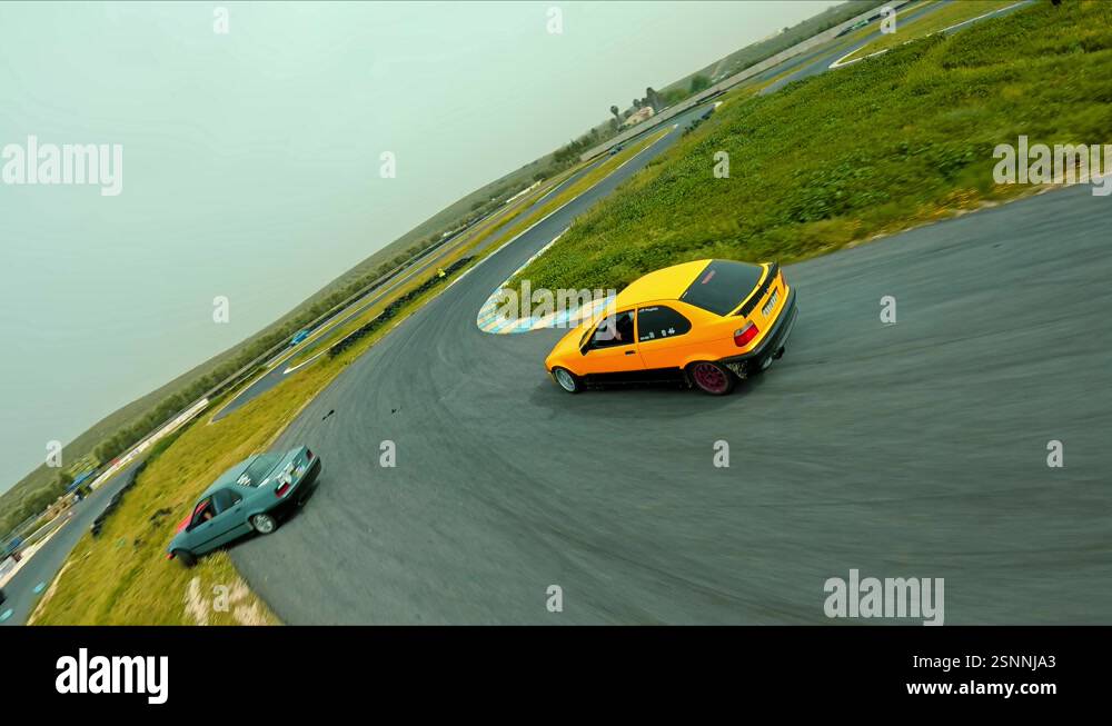 Tracking a yellow car performing drifting on a clear race track, driver ...