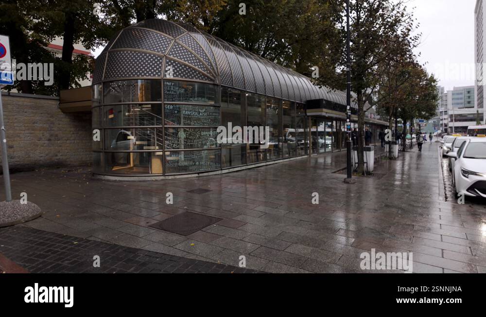 A sleek glass café with modern architecture on a rainy street in ...