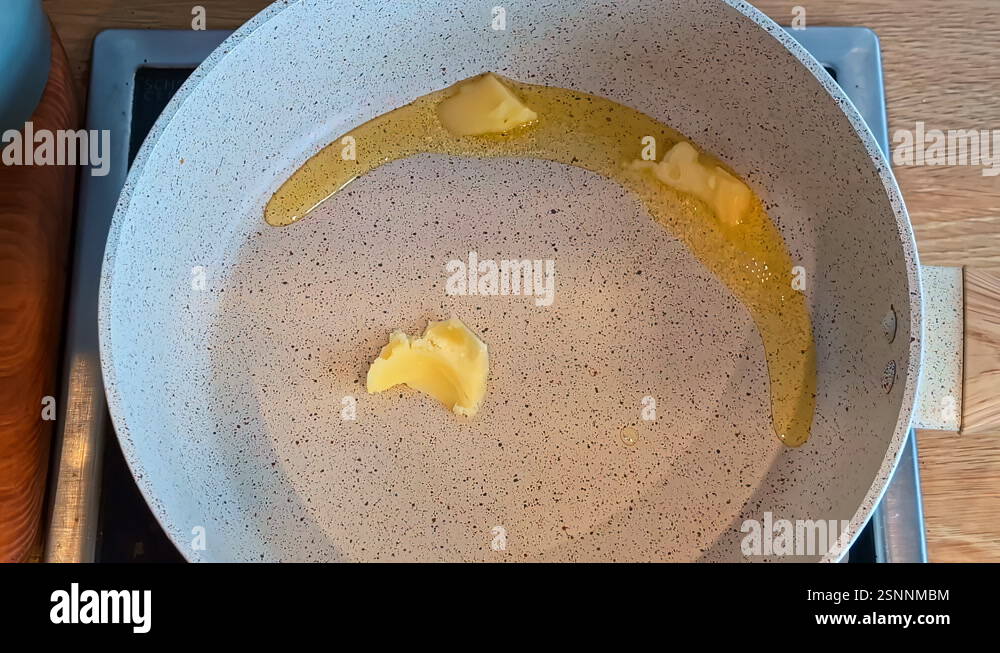 Timelapse of butter slowly melting in a ceramic pan on a hot plate ...