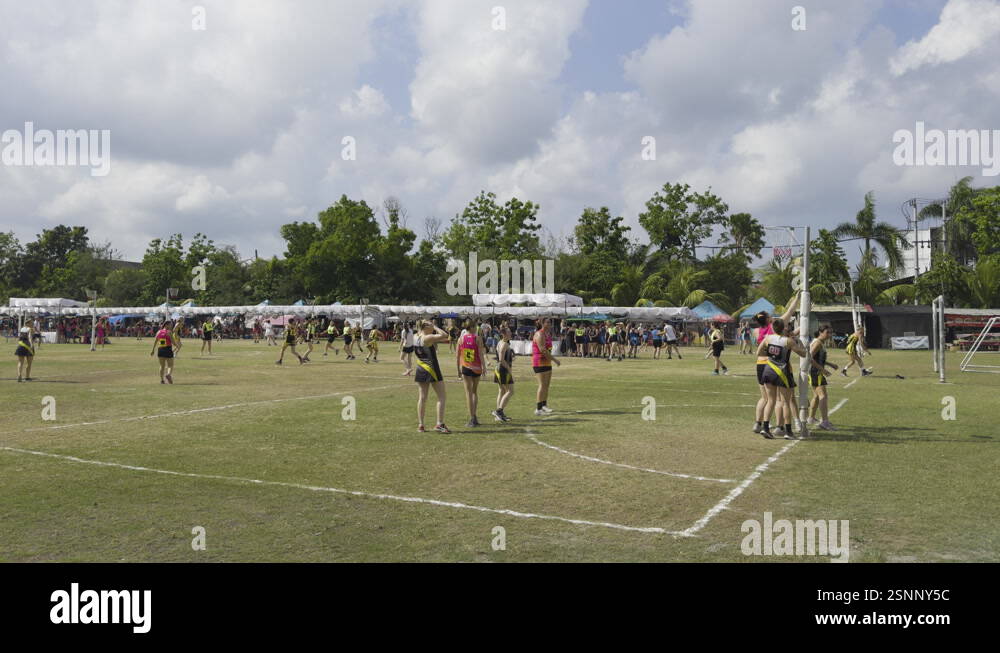 Netball players running and competing on an open grassy field Stock ...