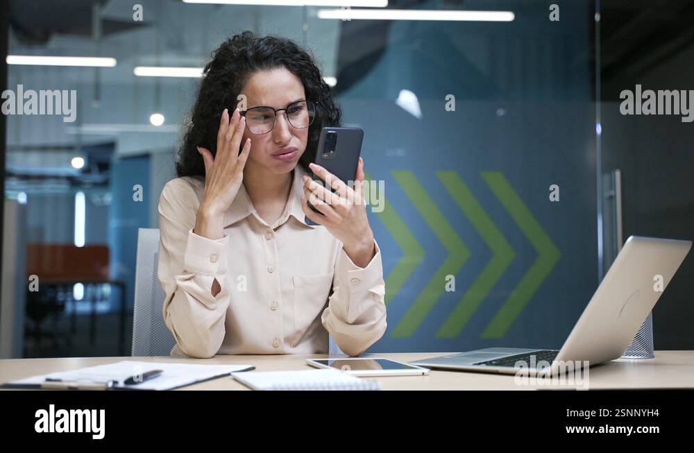 Upset shocked businesswoman reads bad news on mobile phone while ...