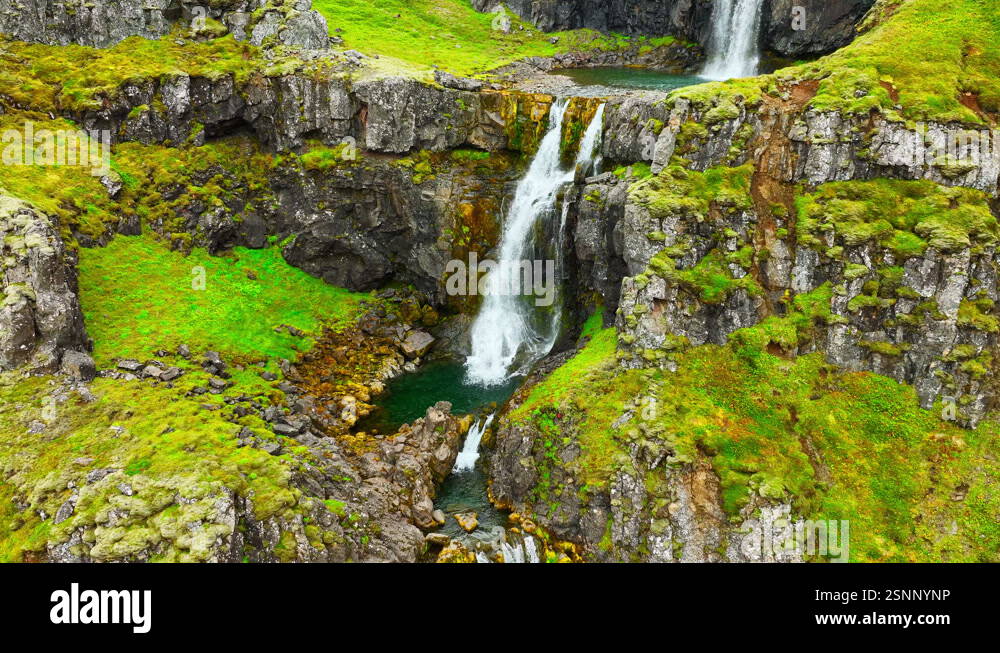 Wispy waterfalls flowing over cliff, Mountain river falling over cliff ...