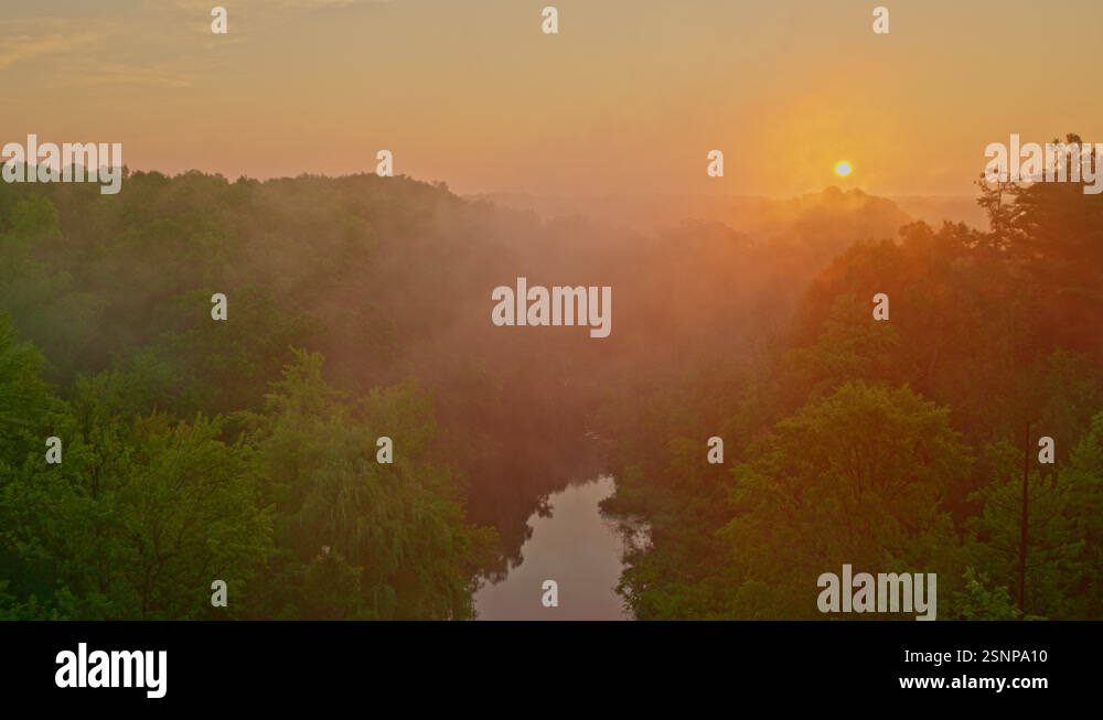 The Huron River, serene and misty at sunrise, viewed from above near ...
