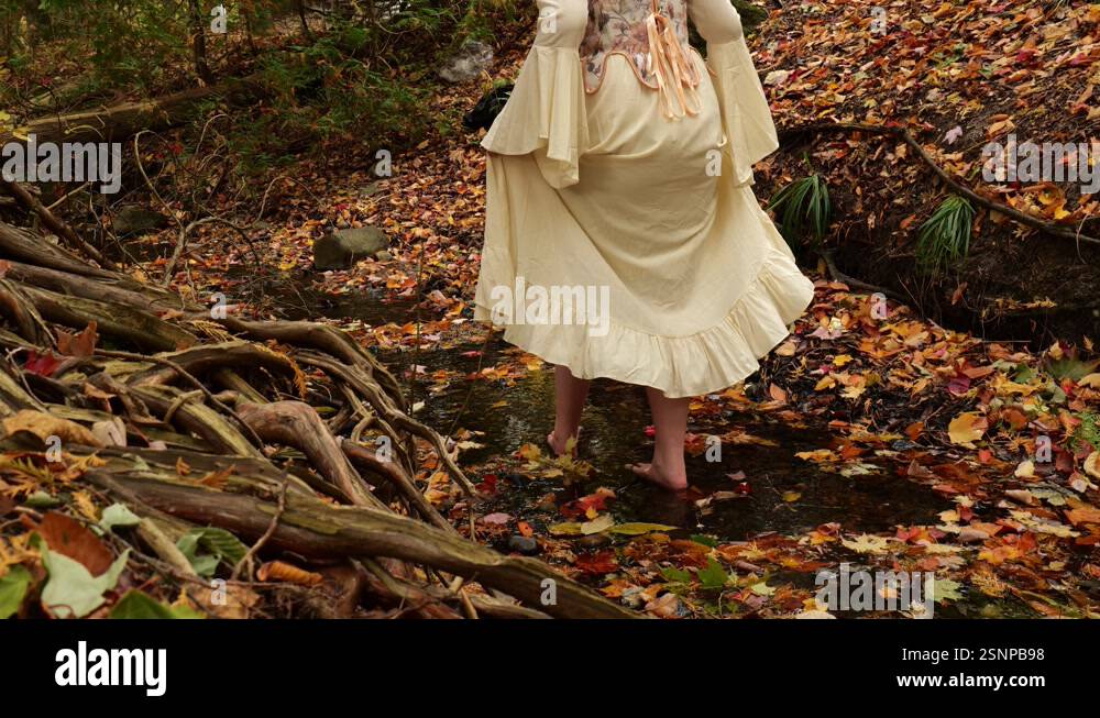 Young Woman Steps Into the Stream and Walks Up the Small River in the ...