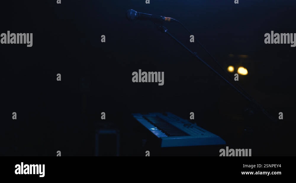 Synthesizer keyboard with a microphone on stage with low lighting ...