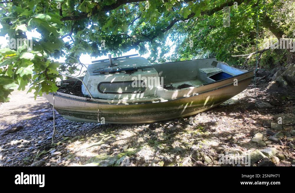 small fiberglass cabin cruiser boat washed up on shore Stock Video ...