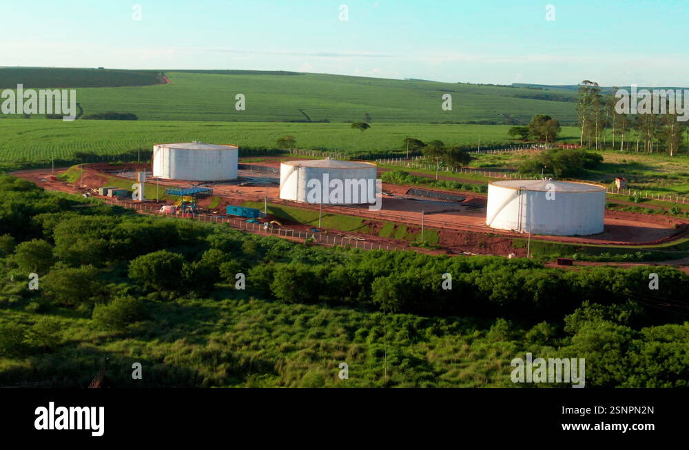 Large white fuel storage tanks in an industrial area surrounded by ...