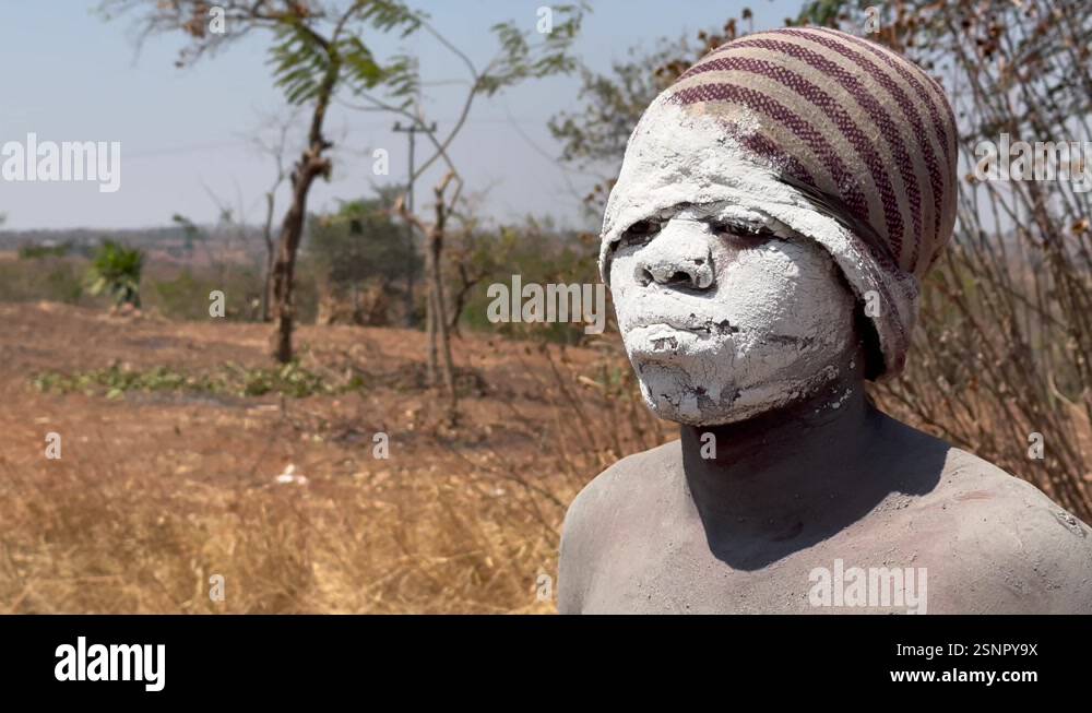 Boy called "Nyau" from the Chewa Tribe covered in mud is representing a ...
