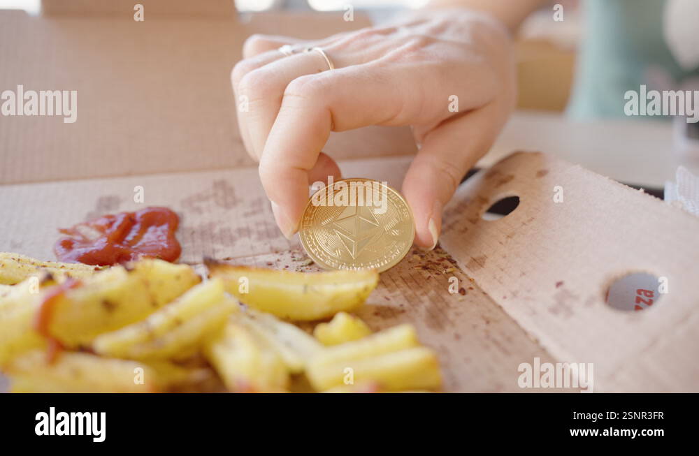 Hand Holding a Golden Ethereum Coin over a Pizza Box with Seasoned ...