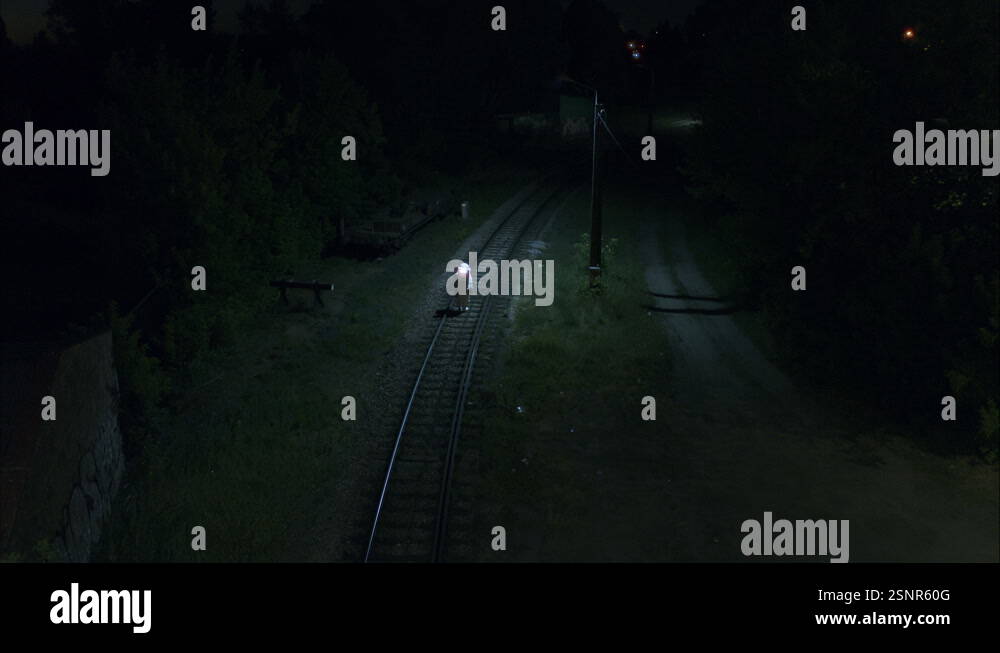 Lone astronaut in spacesuit walks on empty train track at night, aerial Stock Video Footage - Alamy