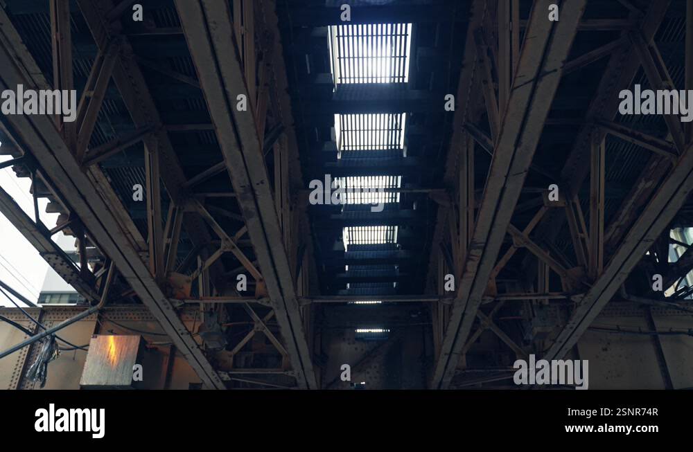Static upward view of elevated rail tracks with trams passing in ...