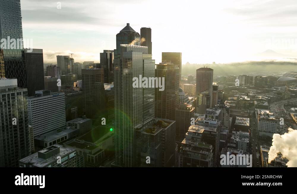 Rising aerial of downtown Seattle reveals skyscrapers backlit by the ...