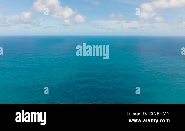 A vast ocean view with a clear horizon under a bright sky filled with ...