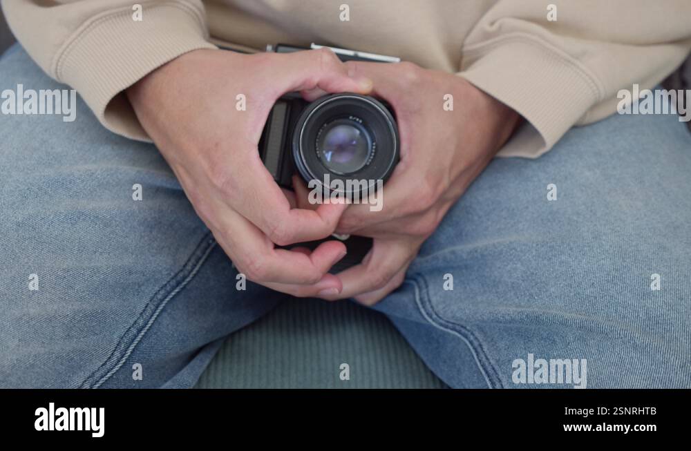 Hands of a boy adjusting the lens of an old compact camera. Close up ...
