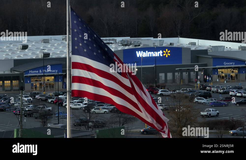 Waving American flag in front of Walmart Shop with many cars on parking ...