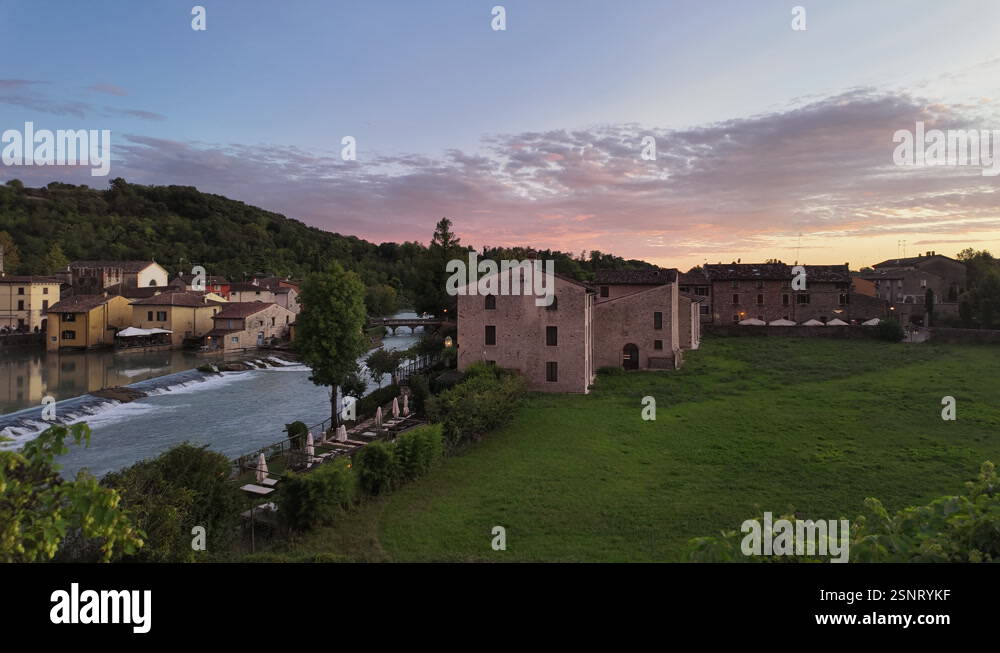 Scenic riverside village with historic buildings and lush greenery ...