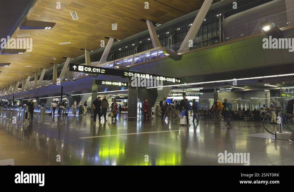 Modern Doha Qatar Airport terminal interior with directional signs and ...