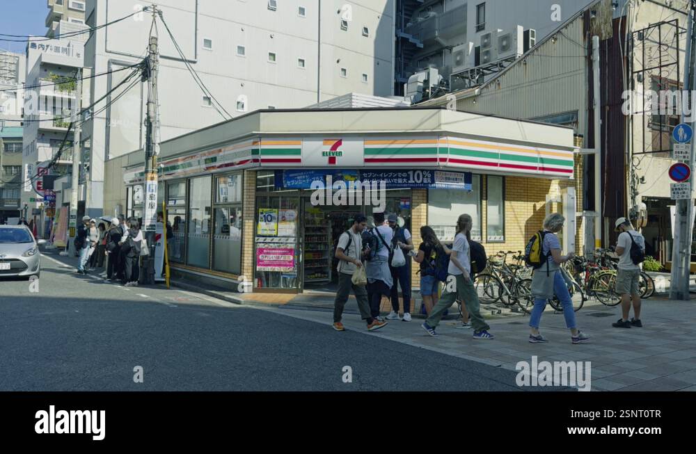 Fixed View of Customers outside small 7-Eleven Convenience Store ...