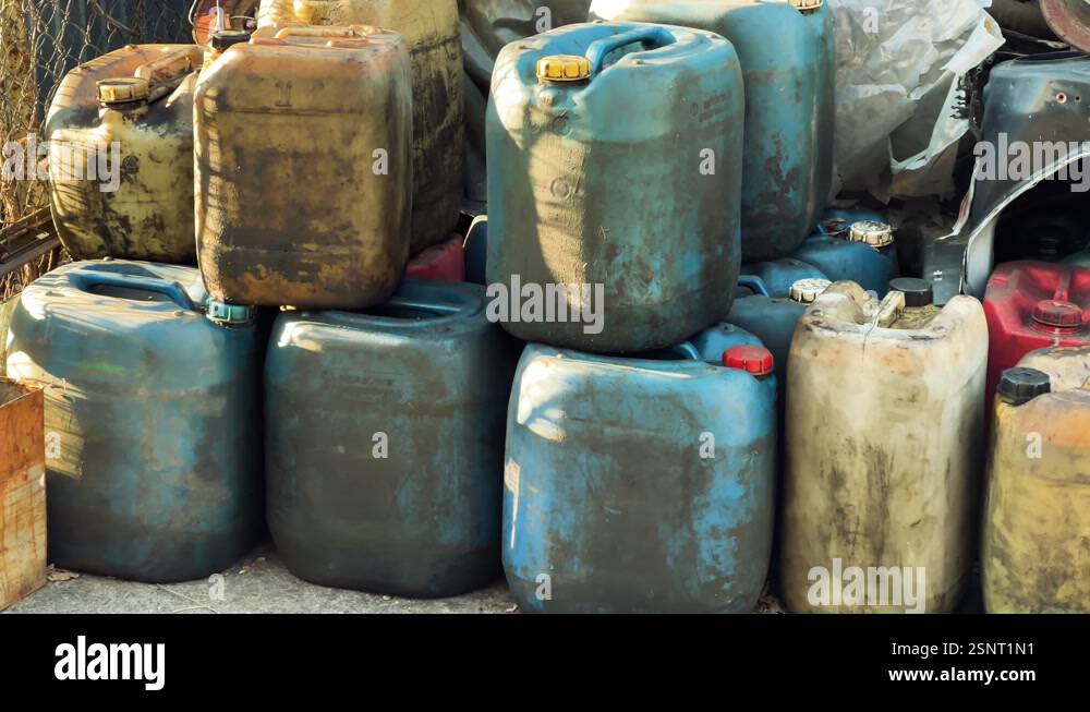 Old plastic containers with used motor oil waiting for proper disposal ...