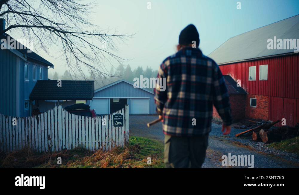 A Man Approaching a Fence With a "Slow Down" Animal Crossing Sign ...