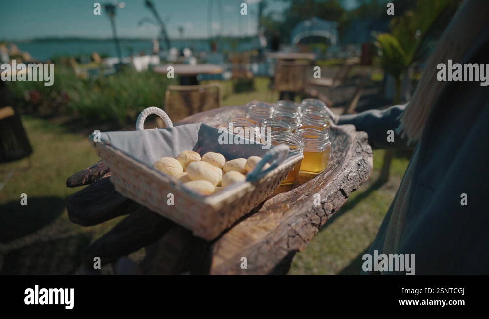 Mate Cocido and Chipá on wooden tray ready to be served by waiter in ...