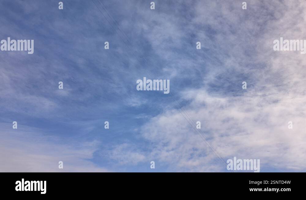 Light high clouds slide on sky. Layer of clouds in blue sky moving ...
