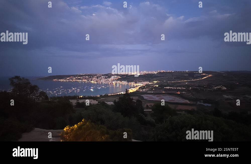 The illuminated Ghadira Bay and Mellieha cityscape from a distance on a ...
