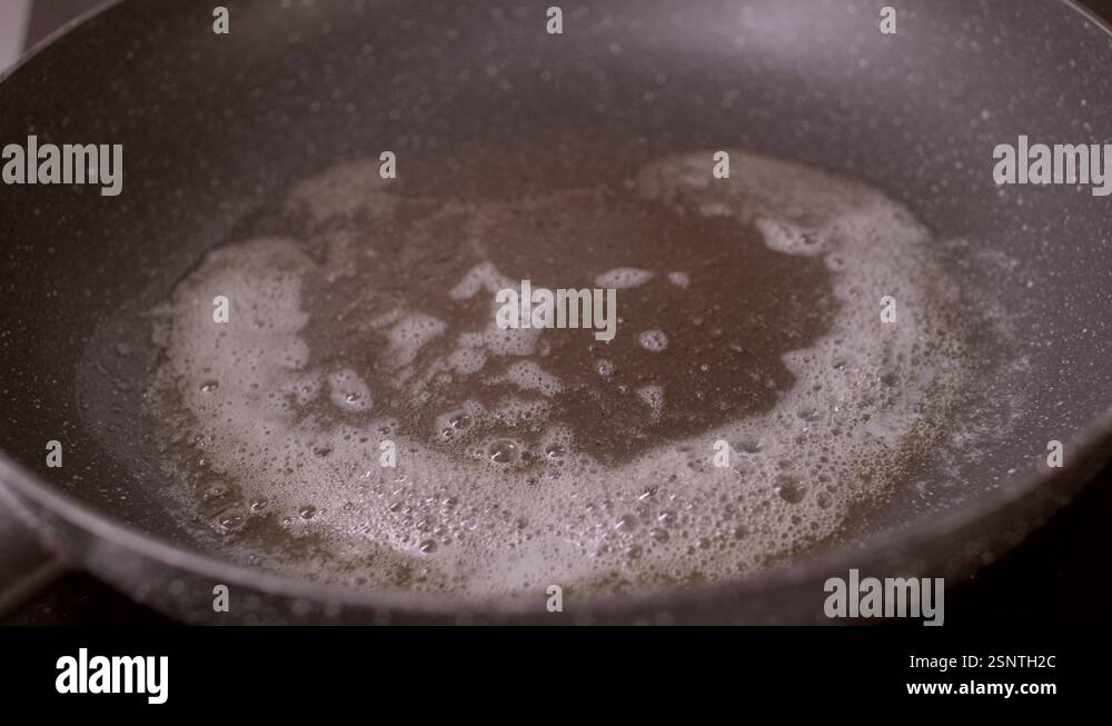 Butter slowly melting deliciously in a sizzling frying pan, creating a ...