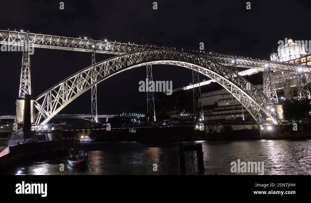 Luí I Bridge, a tall arched bridge, stands illuminated at night in ...