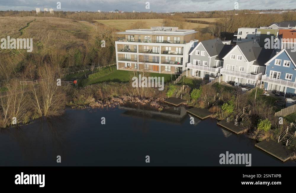 Orbital aerial of an exclusive lakeside flat complex at golden hour ...