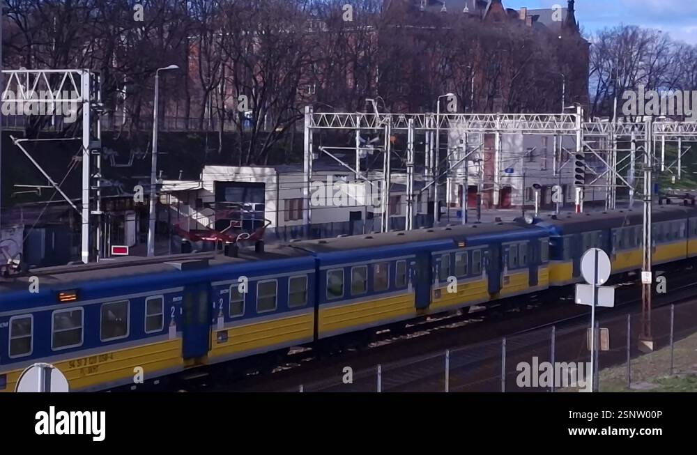 bright yellow and blue electric train makes its way along the tracks ...