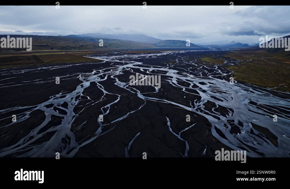 Beauty of a braided river as it wave through a stark volcanic landscape ...