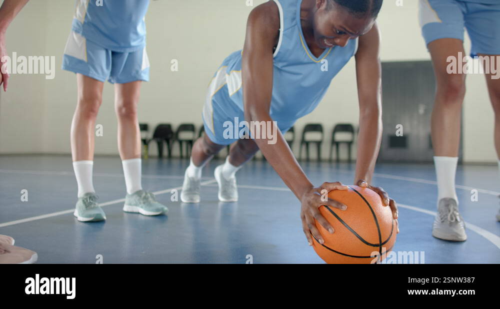 Exercising in gym, female basketball player doing push-ups using ...