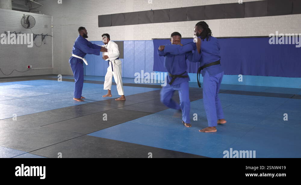 Practicing judo, athletes in martial arts uniforms training in dojo ...