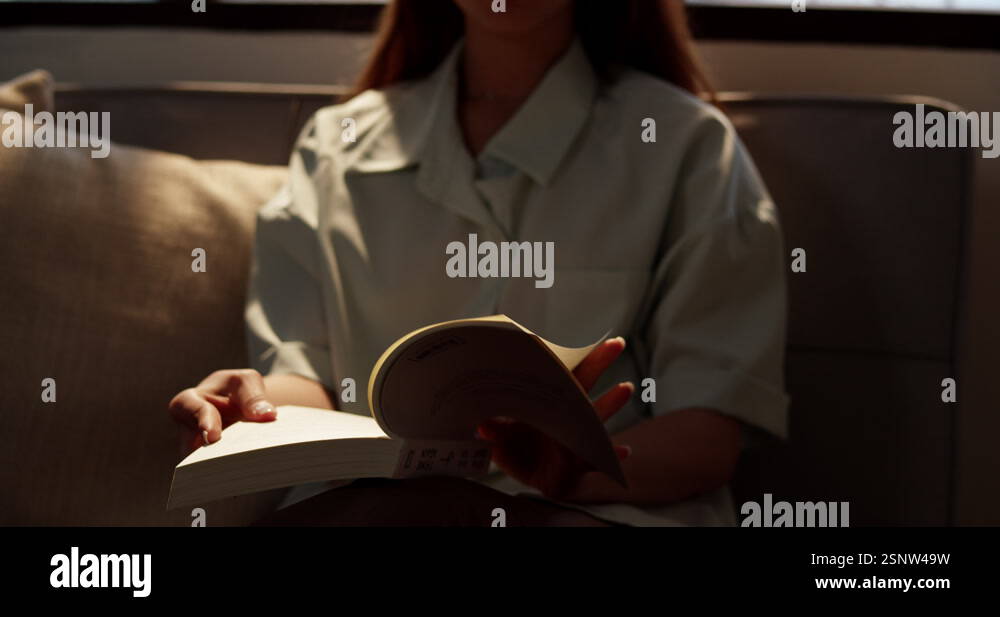 A serene moment captured as a person enjoys reading at home reflecting ...