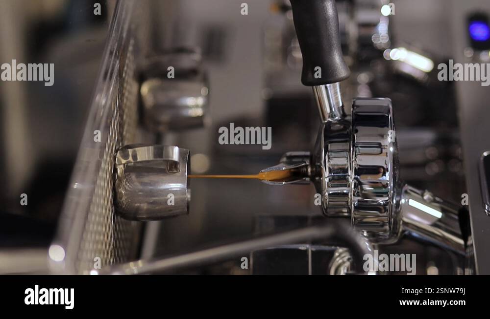 Coffee stream from coffee machine flows into cup. Using filter holder ...