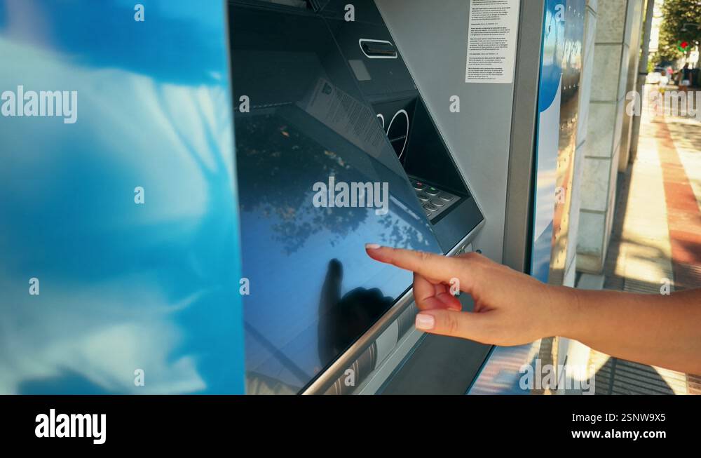 Person using ATM machine withdraw cash outdoor. Inserting card in ATM ...