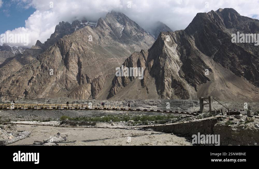 A precarious bridge over a roaring river in Pakistan among the ...