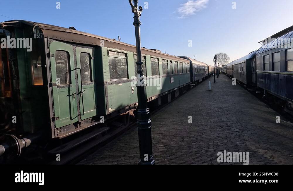 Walking between vintage steam engine passenger carts on a train station ...