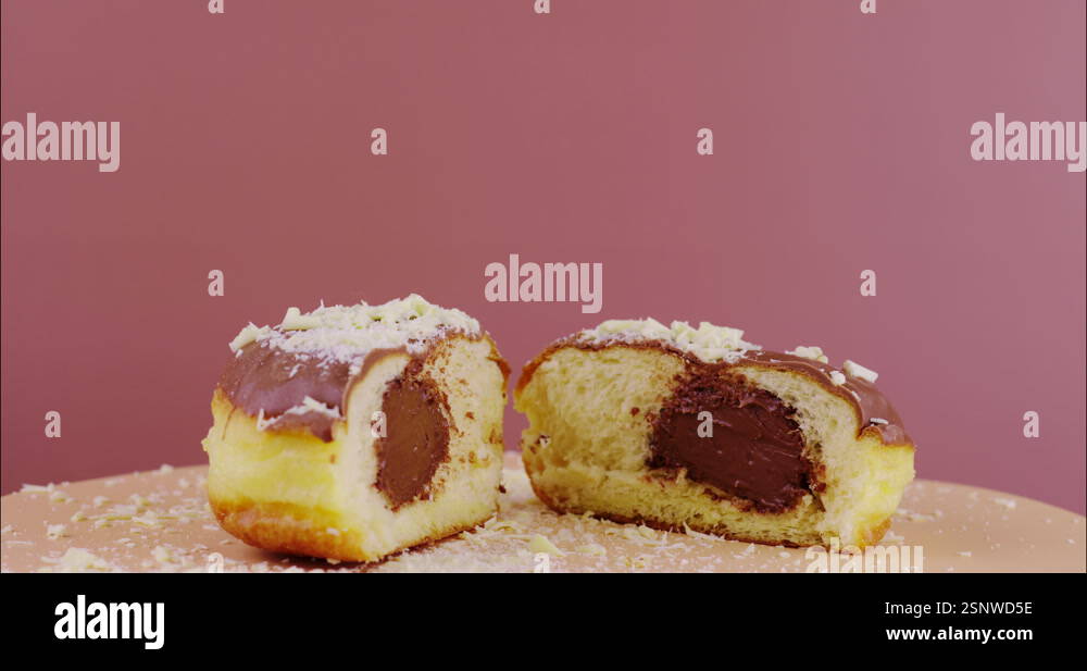 A Berliner donut rotates on display, revealing a rich chocolate filling ...