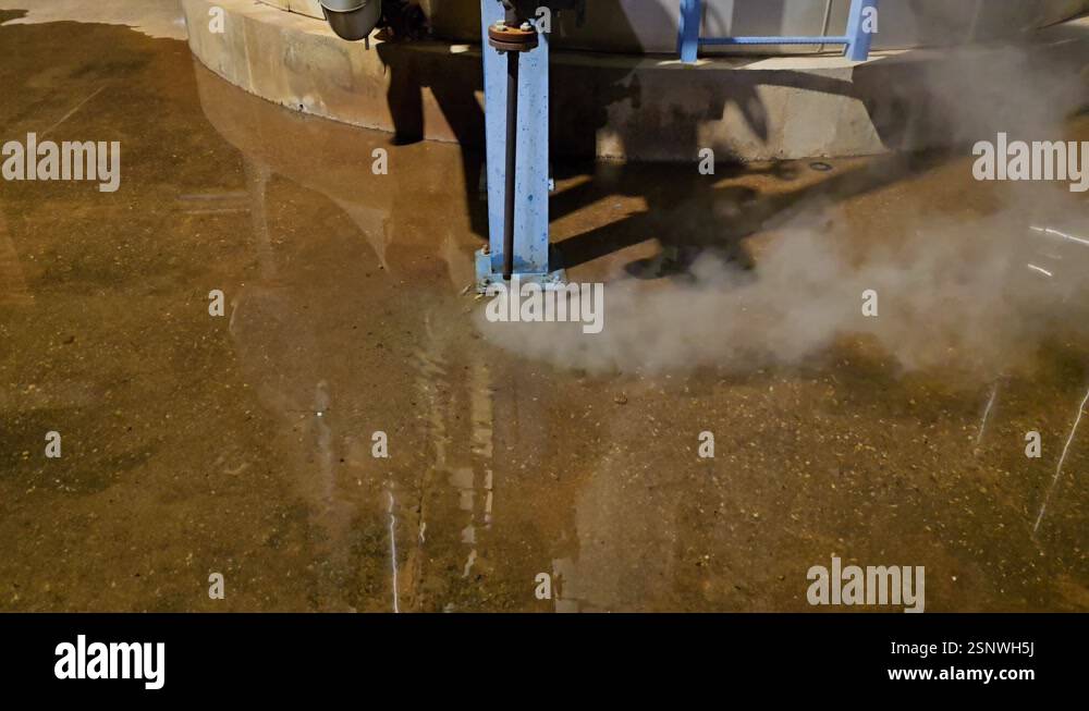 Steam escaping from a pipe in a chemical factory during the night shift ...