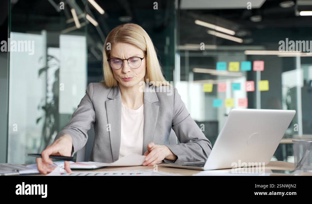 Confused distracted businesswoman having difficulty with paper work in ...