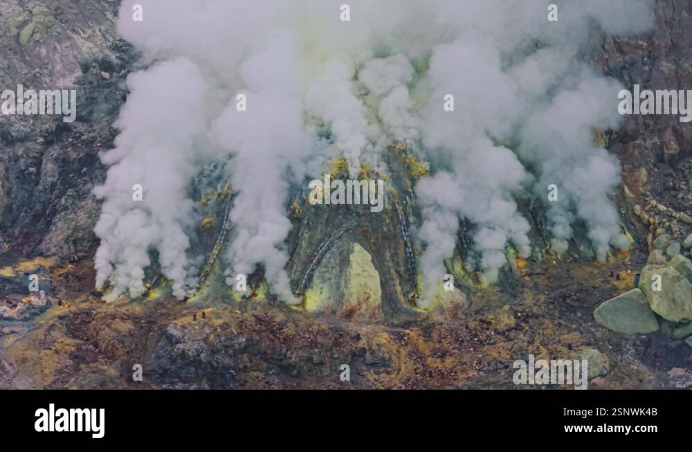 Ijen Volcano with rising sulfur gas clouds in a dramatic volcanic ...